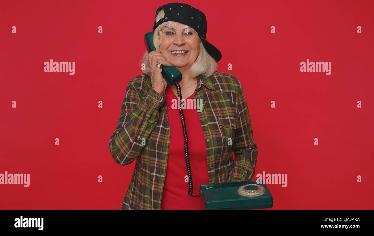 Cheerful tourist woman secretary talking on wired vintage telephone of ...