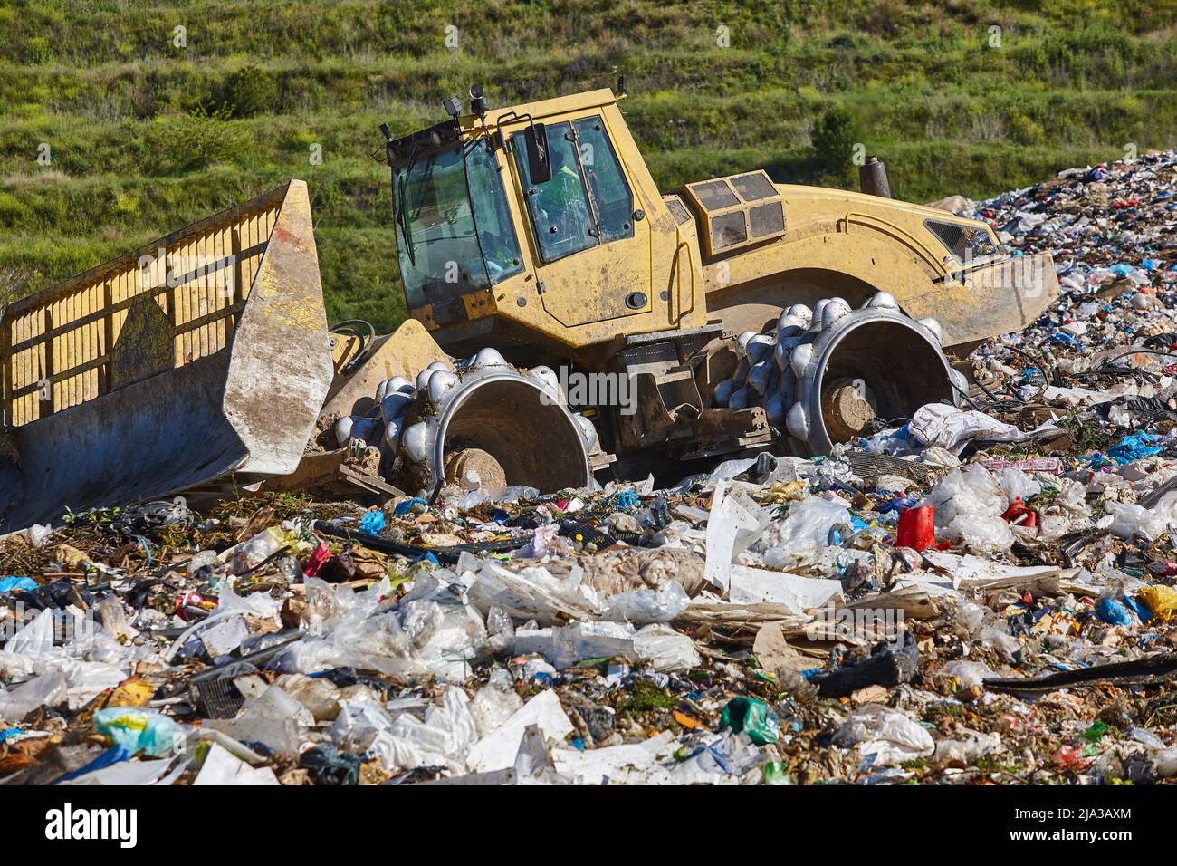 Heavy machinery shredding garbage in an open air landfill. Waste Stock ...