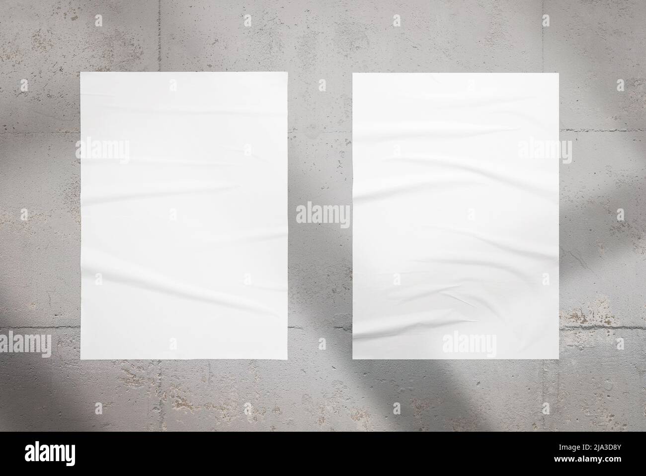 Two posters on the interior wall with a window light over. Blank ...