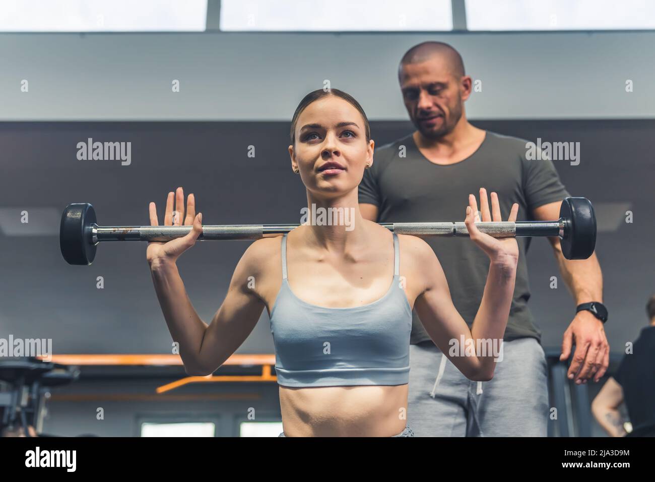 Indoor gym portrait of a focused confident brunette in a gray sports ...