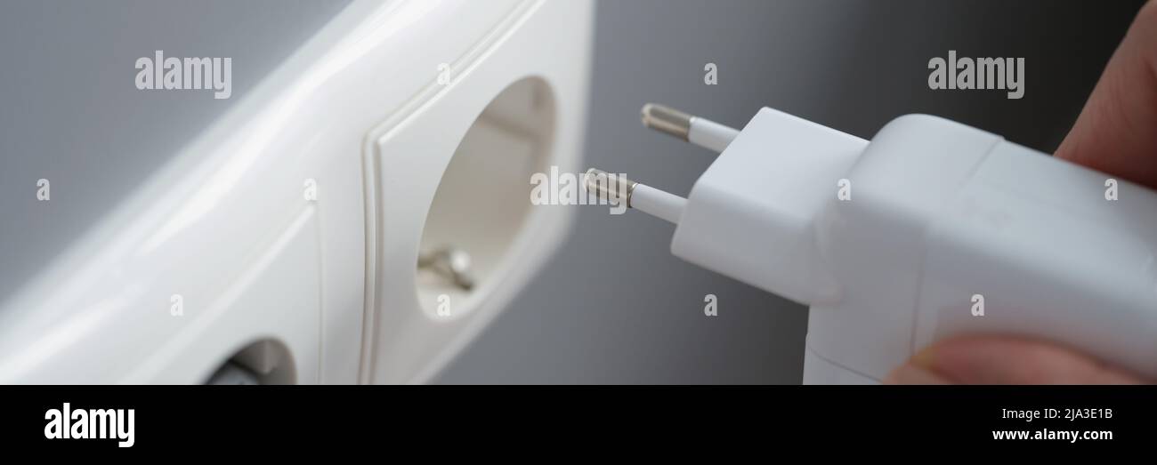 Hand inserts laptop power supply into the socket Stock Photo - Alamy