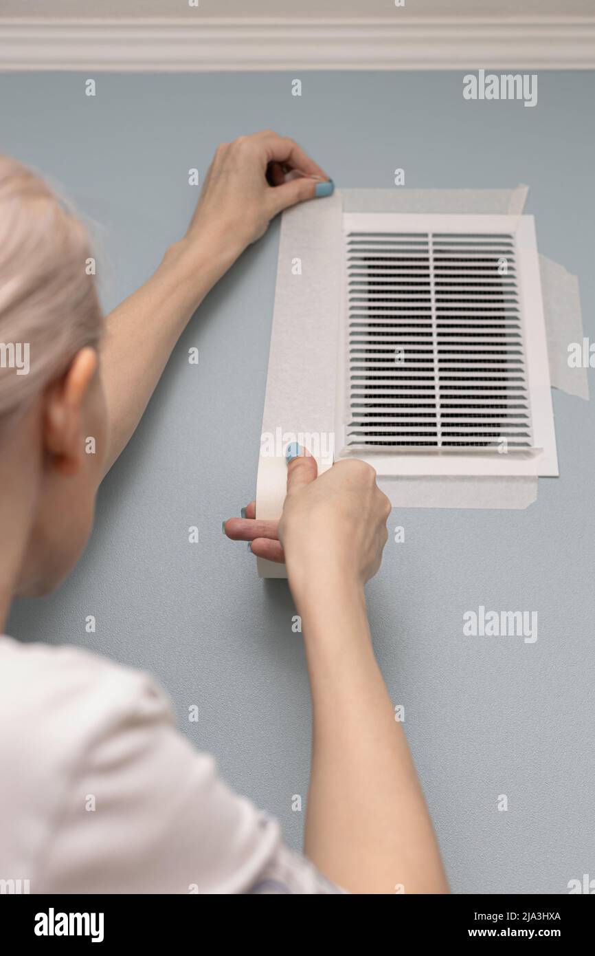 a woman fixes a ventilation grate glued to the wall. High quality photo Stock Photo - Alamy