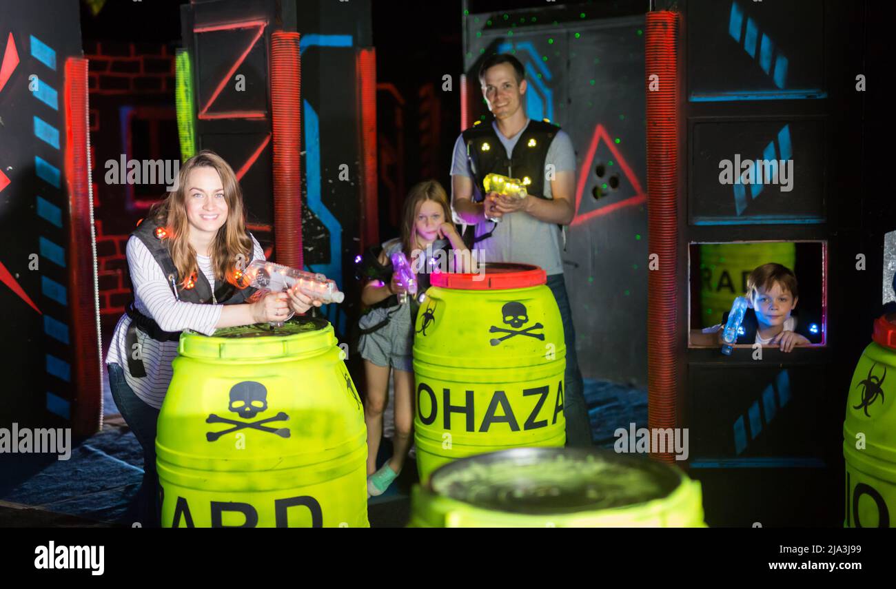 Woman playing laser tag with family Stock Photo - Alamy