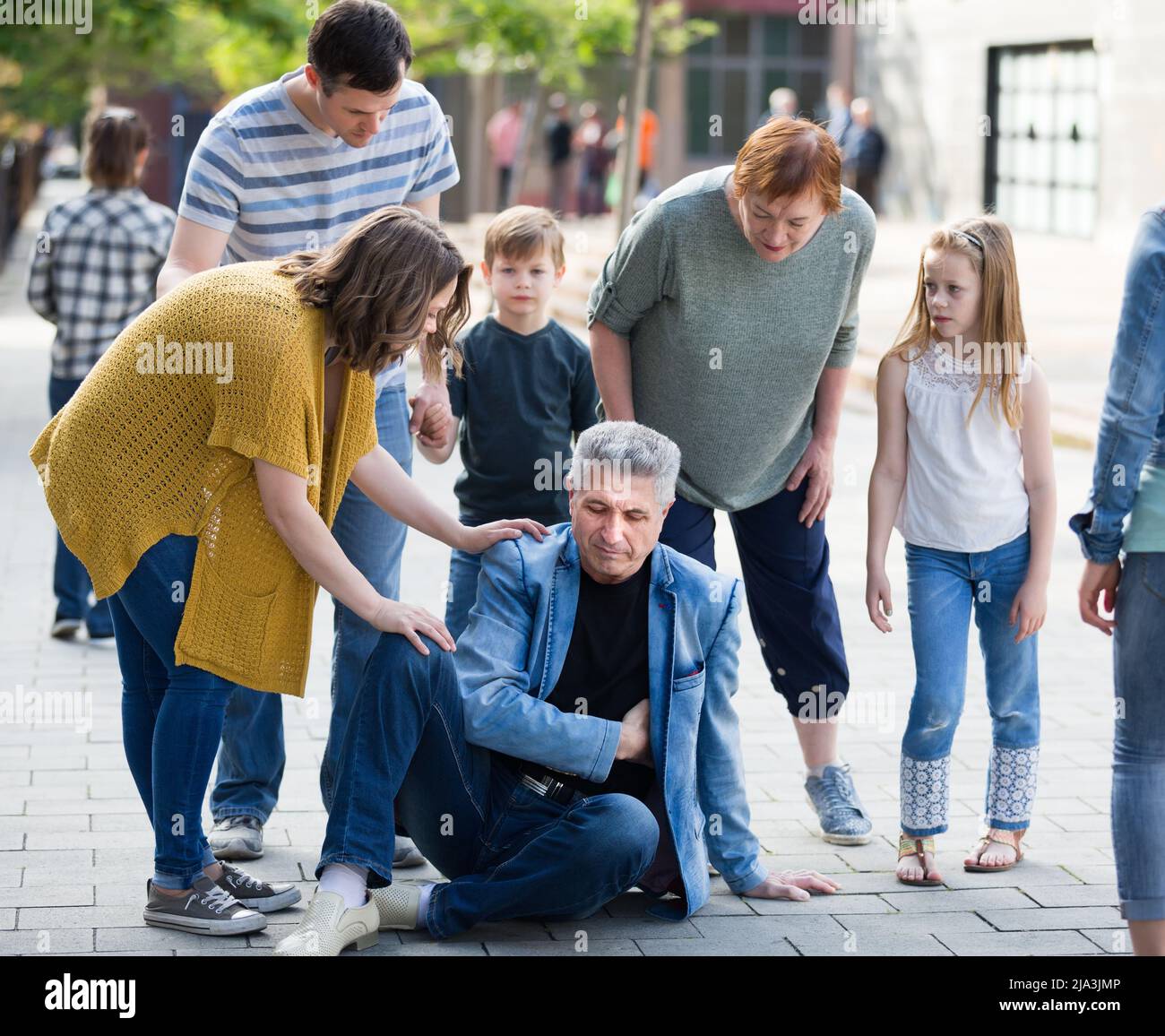 People of different ages helping mature male Stock Photo - Alamy