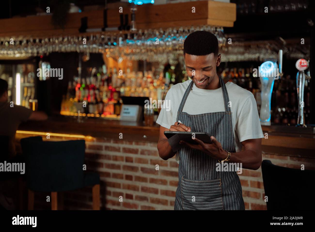 African American waiter working in restaurant on digital tablet Stock ...