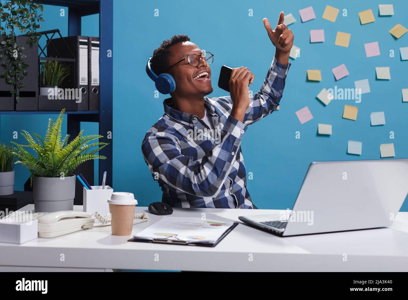 Relaxed company employee doing karaoke while sitting in office ...