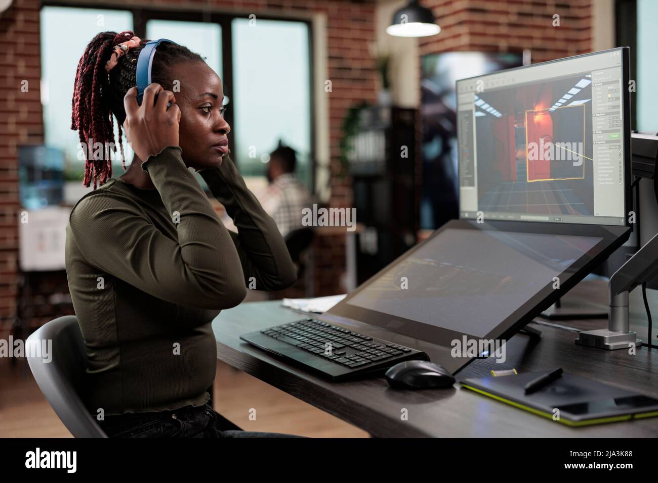 Level design department employee wearing wireless headphones while ...