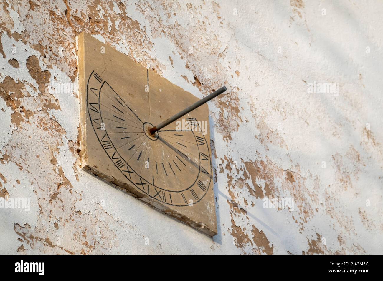 Weathered old sun clock on a wall Stock Photo - Alamy