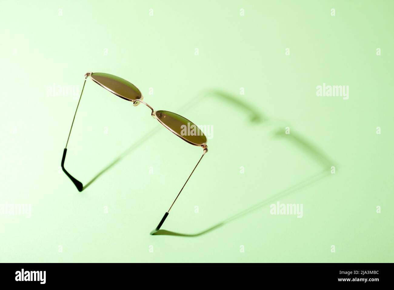Minimalist image of sunglasses with shadow on green background Stock ...