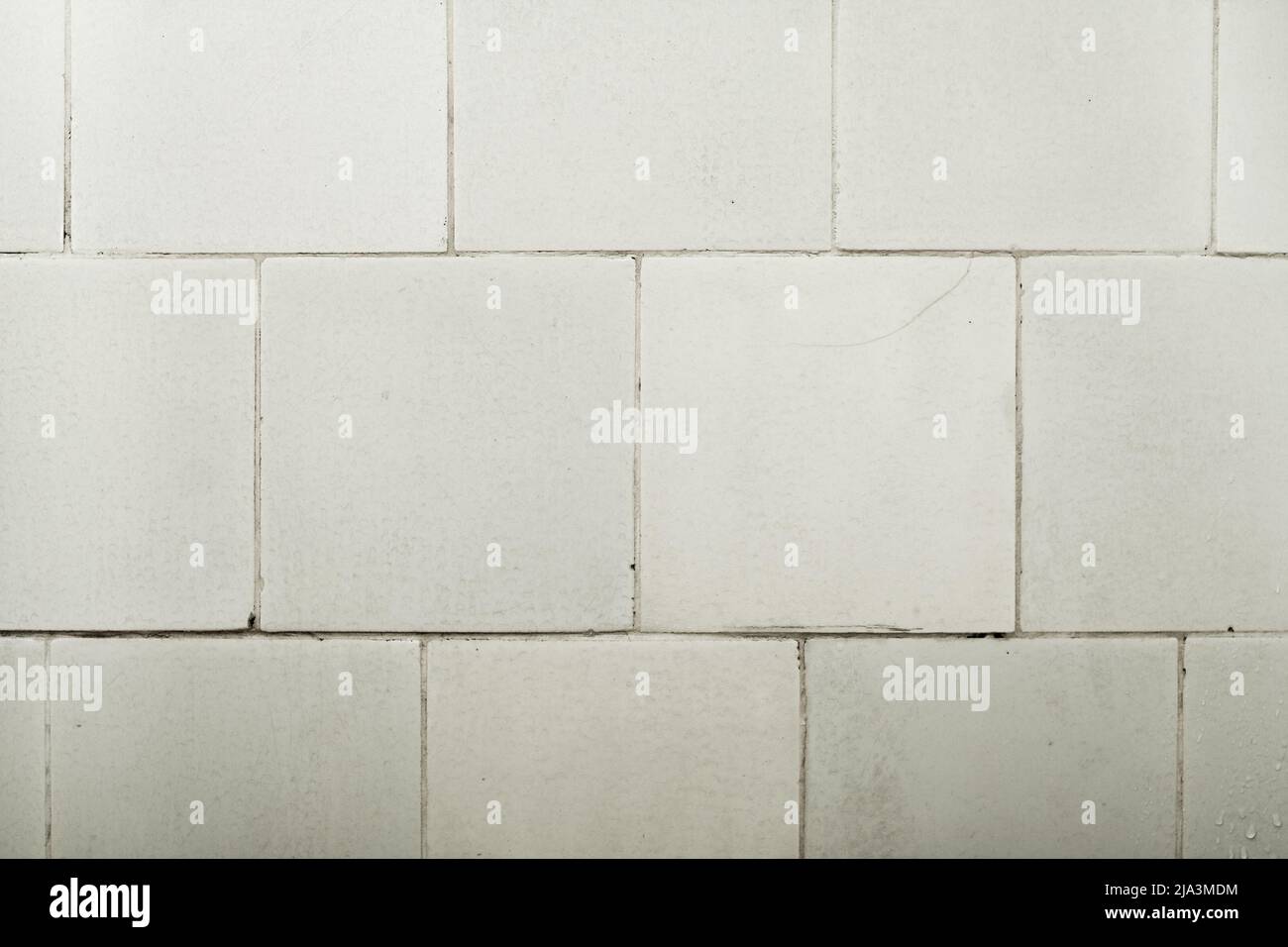 Old style bathroom wall decorated with square ceramic tile. Old white ...