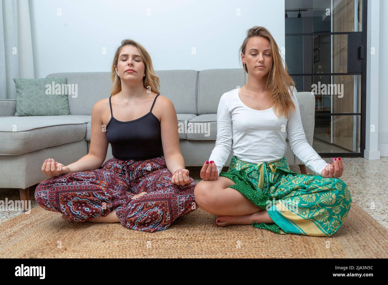couple of beautiful women doing meditation at home Stock Photo - Alamy