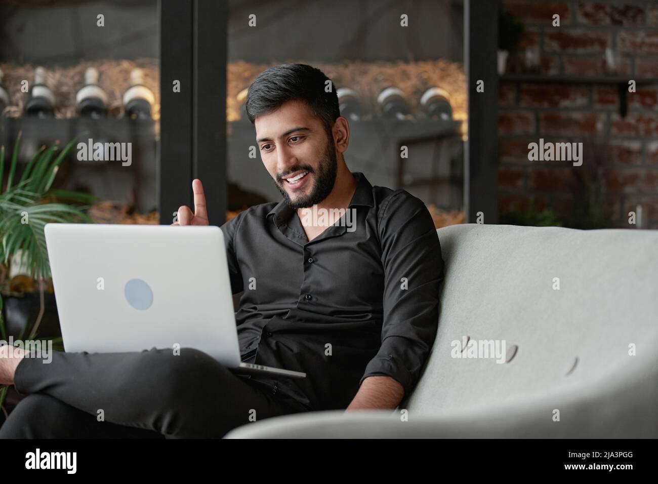 satisfied wine shop owner looking at his laptop screen Stock Photo - Alamy