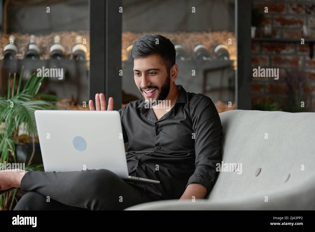 satisfied wine shop owner looking at his laptop screen Stock Photo - Alamy