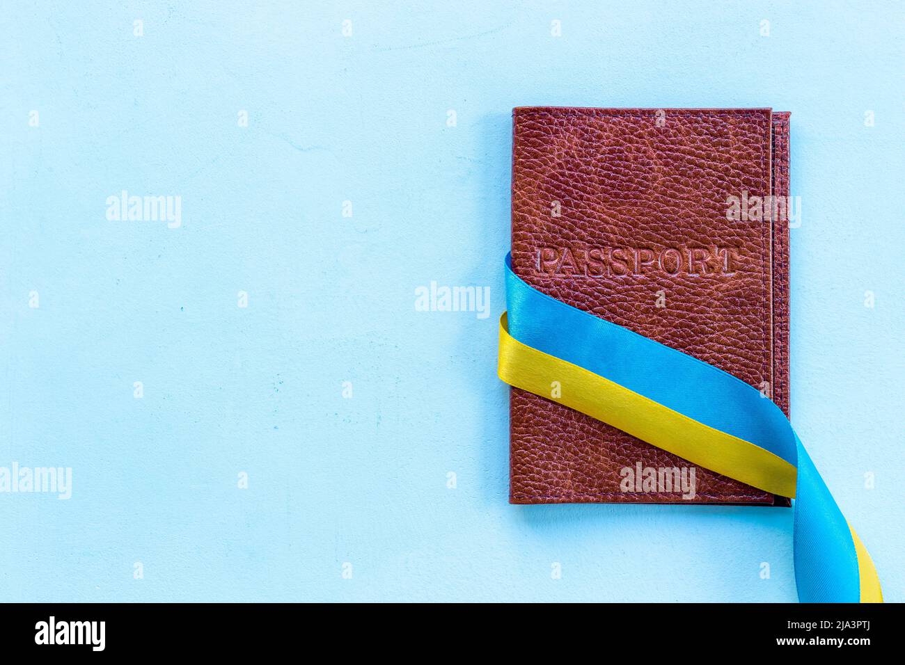 Ukrainian immigration concept - yellow and blue ribbon on passport ...