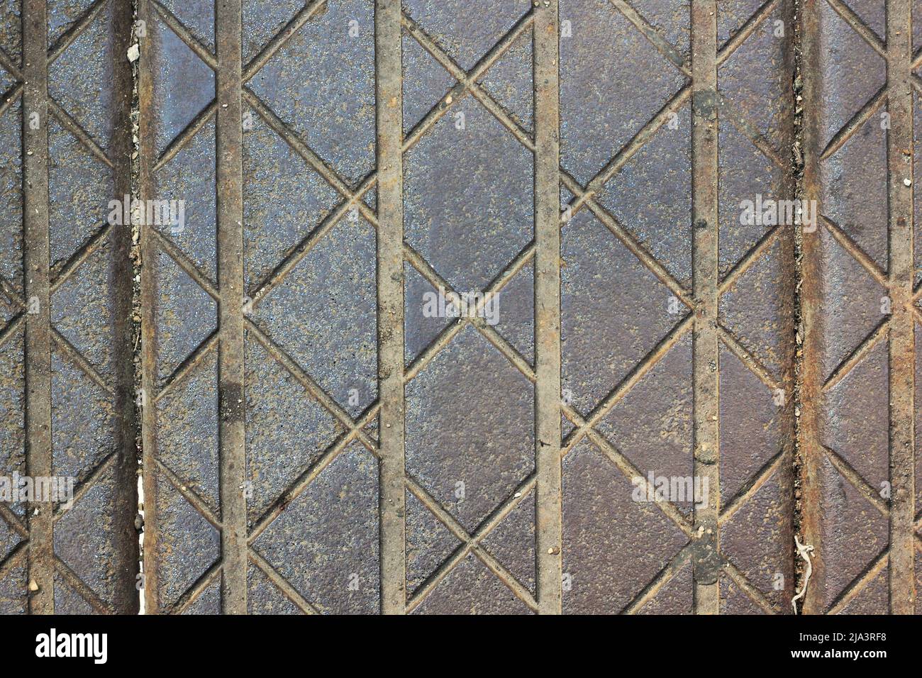 Heavy security grill on a glass window with diagonal metal pattern ...