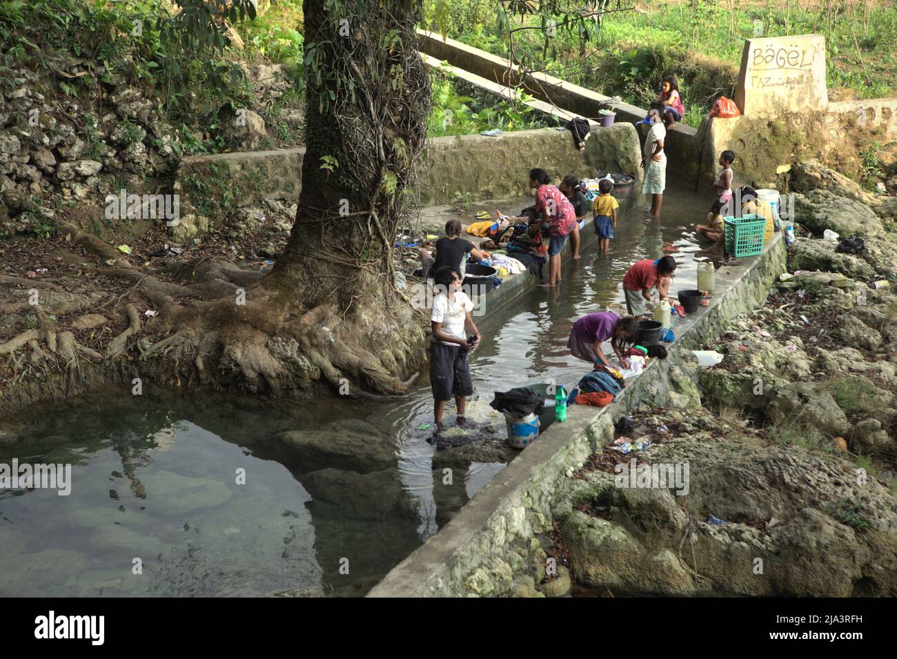 Women washing clothes at an irrigation canal near Waikelo Sawah, a rare ...