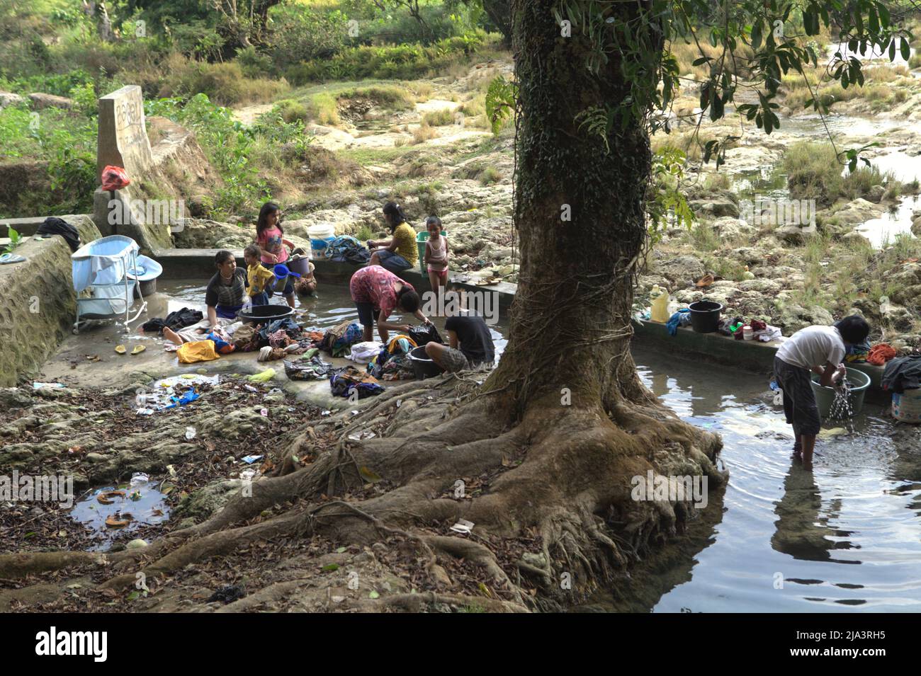 Women washing clothes at an irrigation canal near Waikelo Sawah, a rare ...