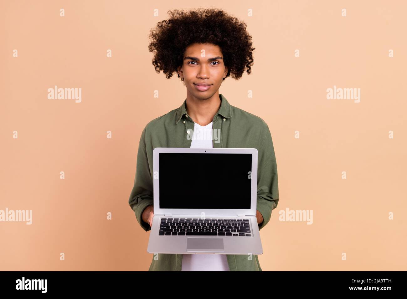 Portrait of attractive serious trendy wavy-haired guy holding laptop ...