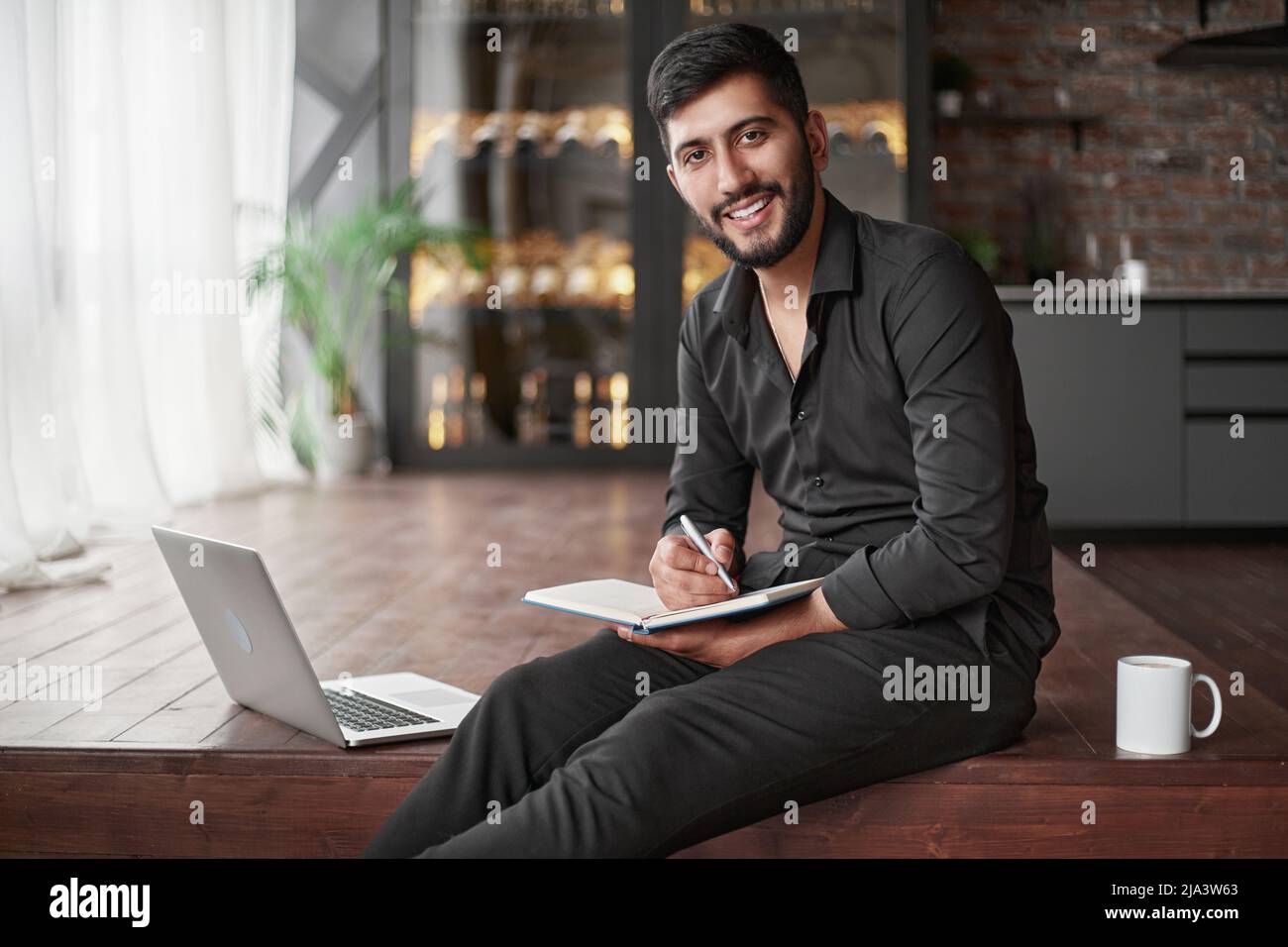 owner of a new business is taking notes in a notebook while sitting on ...