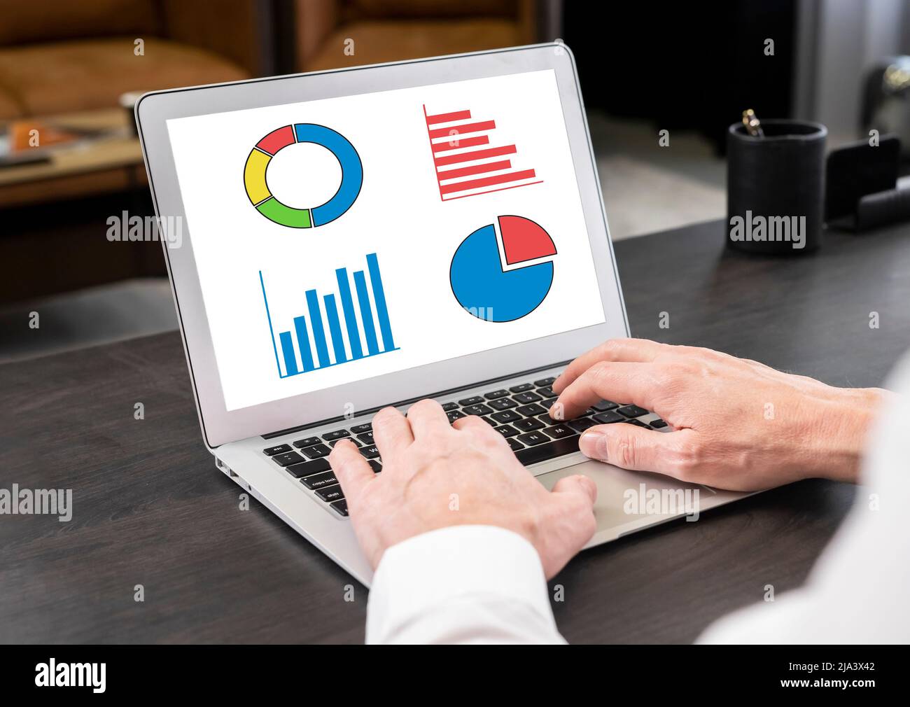 Businessman working on laptop with bar graphs and diagrams at screen ...