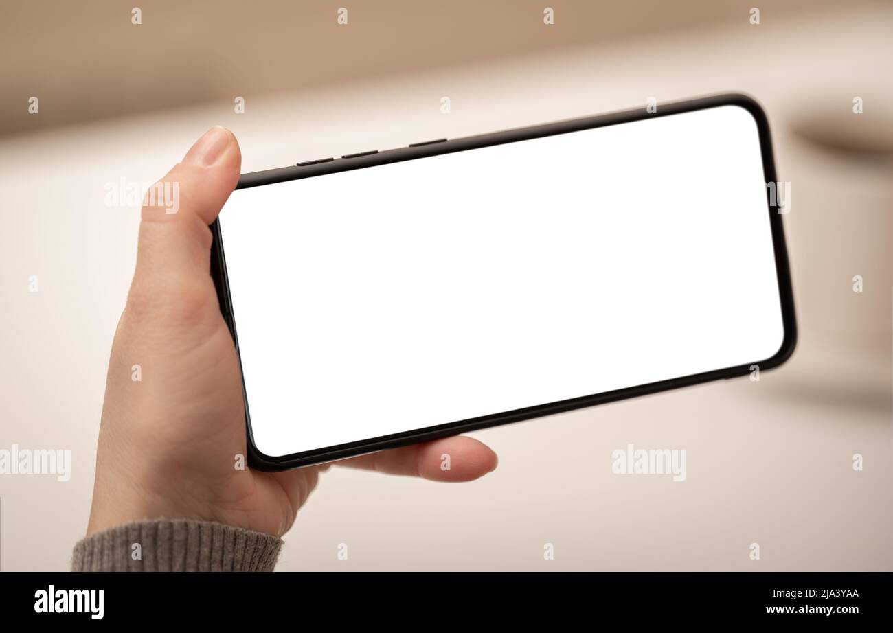Mockup cell phone. female hand holding phone horizontally with blank ...