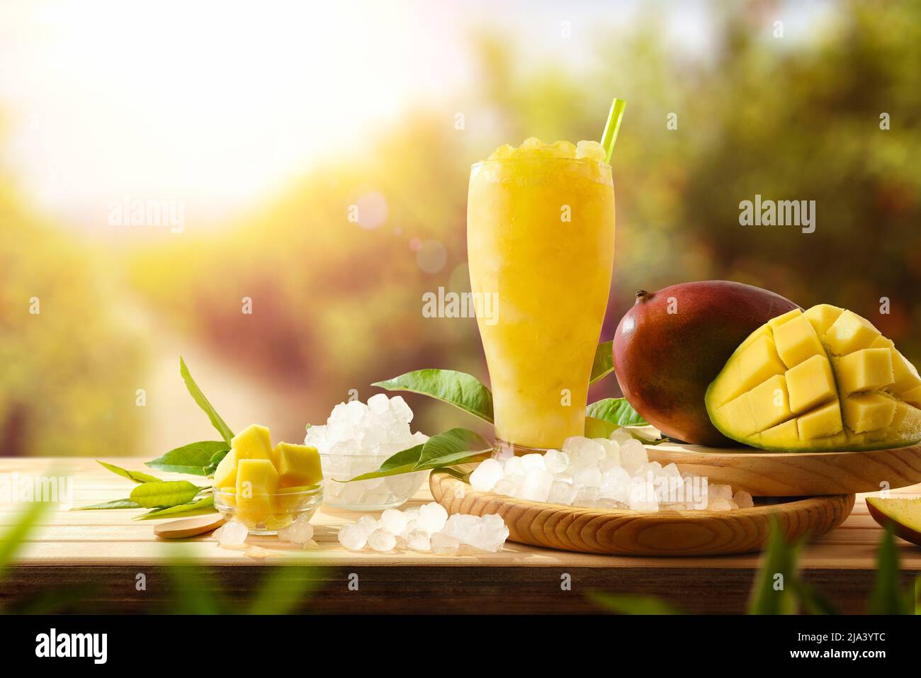 Mango slush with fruit and crushed ice around it on a wooden table ...