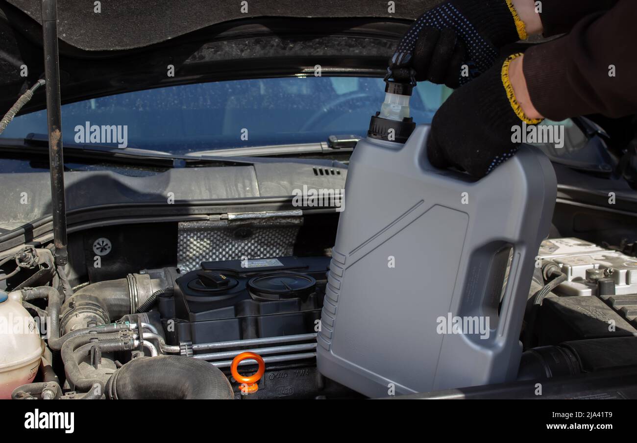 Refueling and pouring oil quality into the engine motor car ...