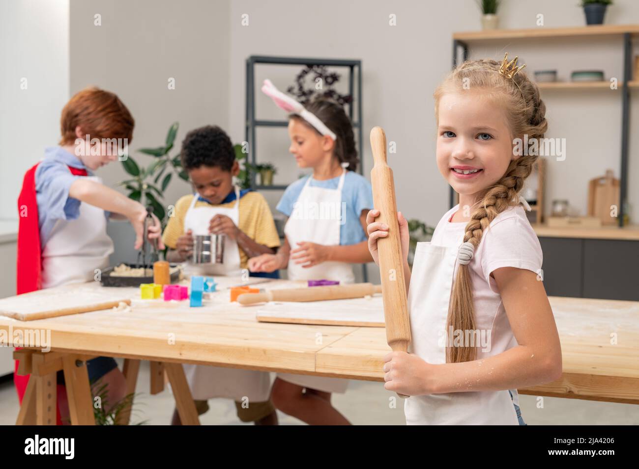 Happy cute boy holding tray with raw selfmade cookies while standing by ...