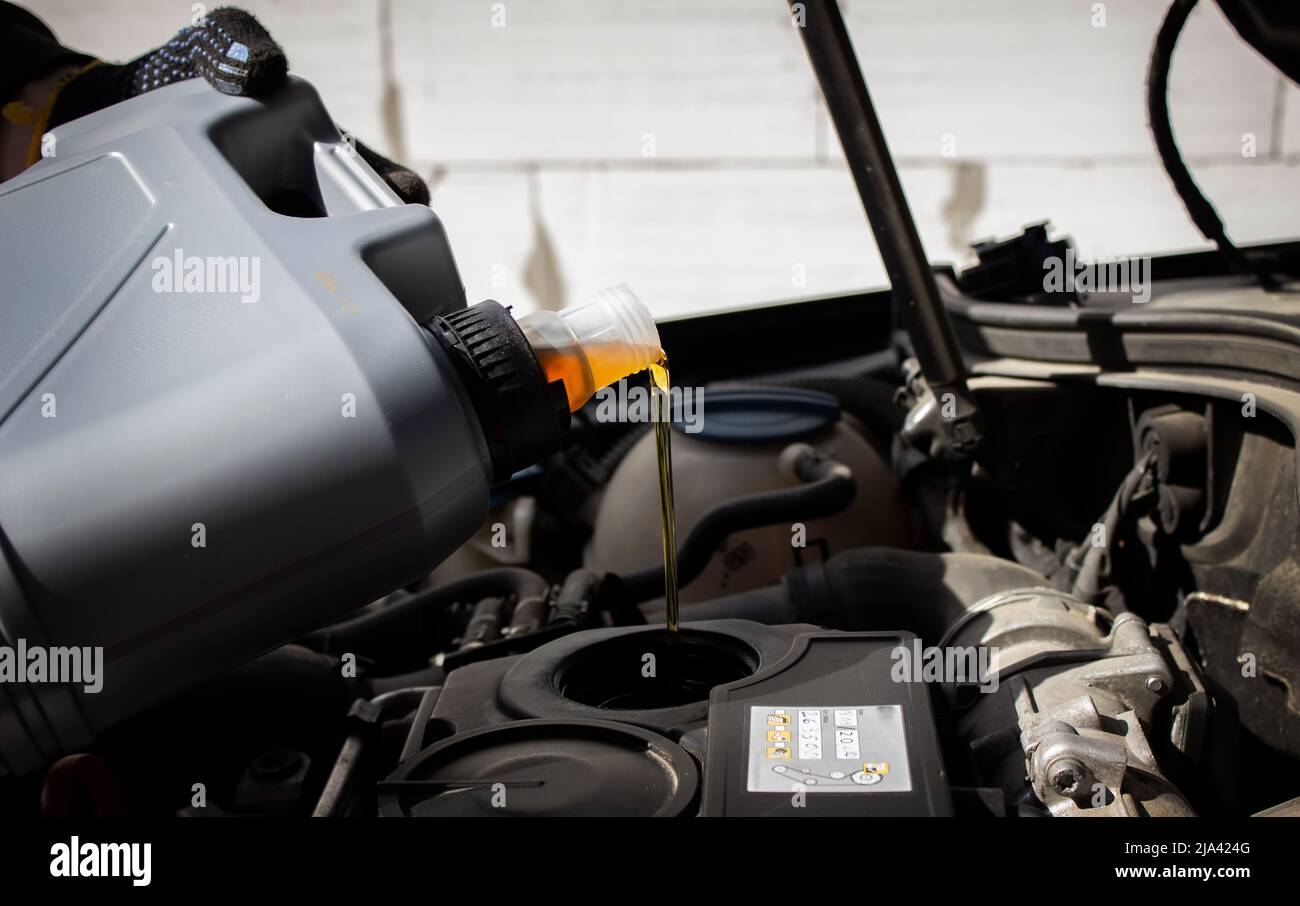 Refueling and pouring oil quality into the engine motor car ...