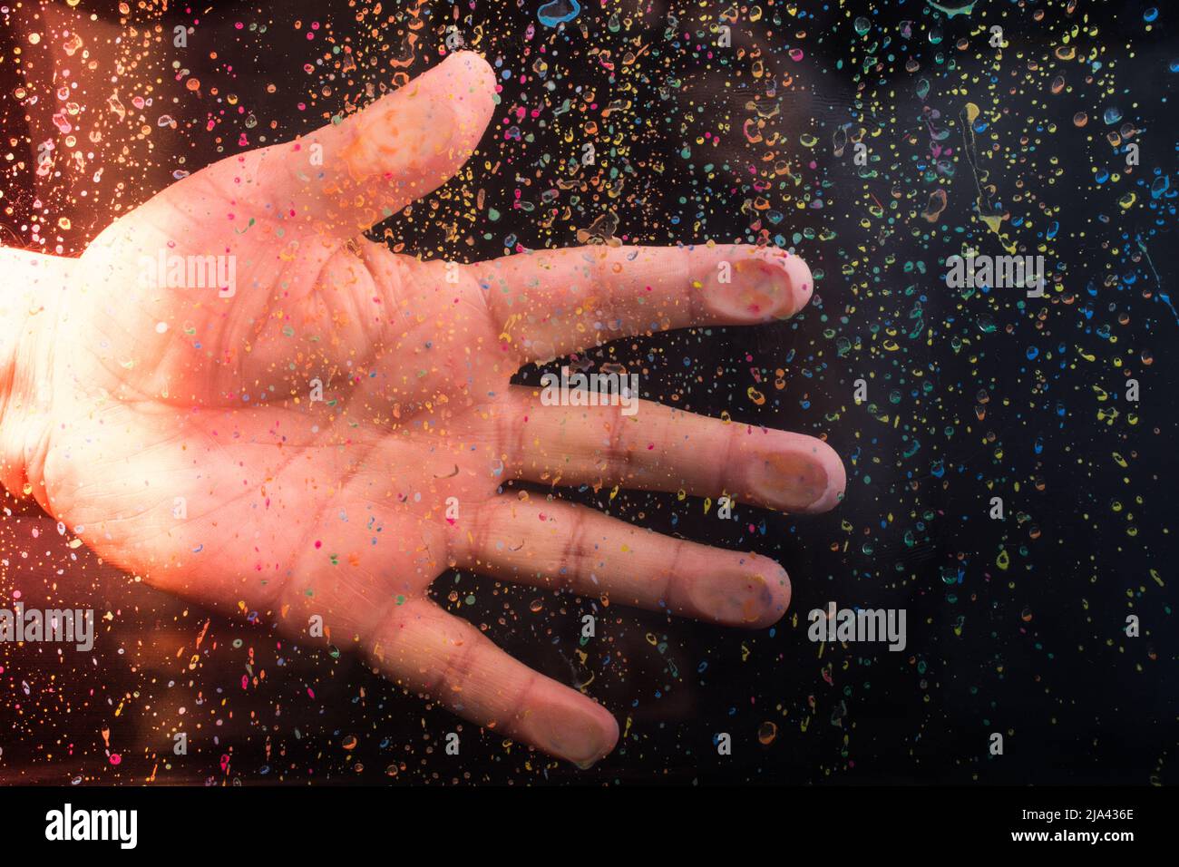 Hand on a glass with a paint splash effect on a black background Stock ...