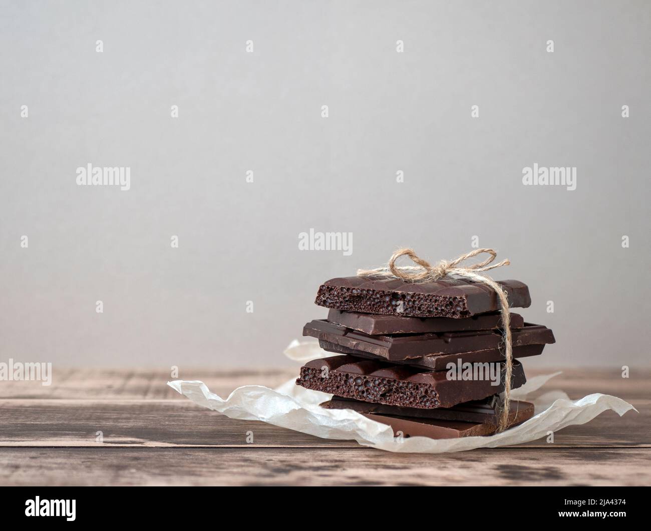 Stuck of chocolate bars on wooden table, copy space. Stacked pieces of ...