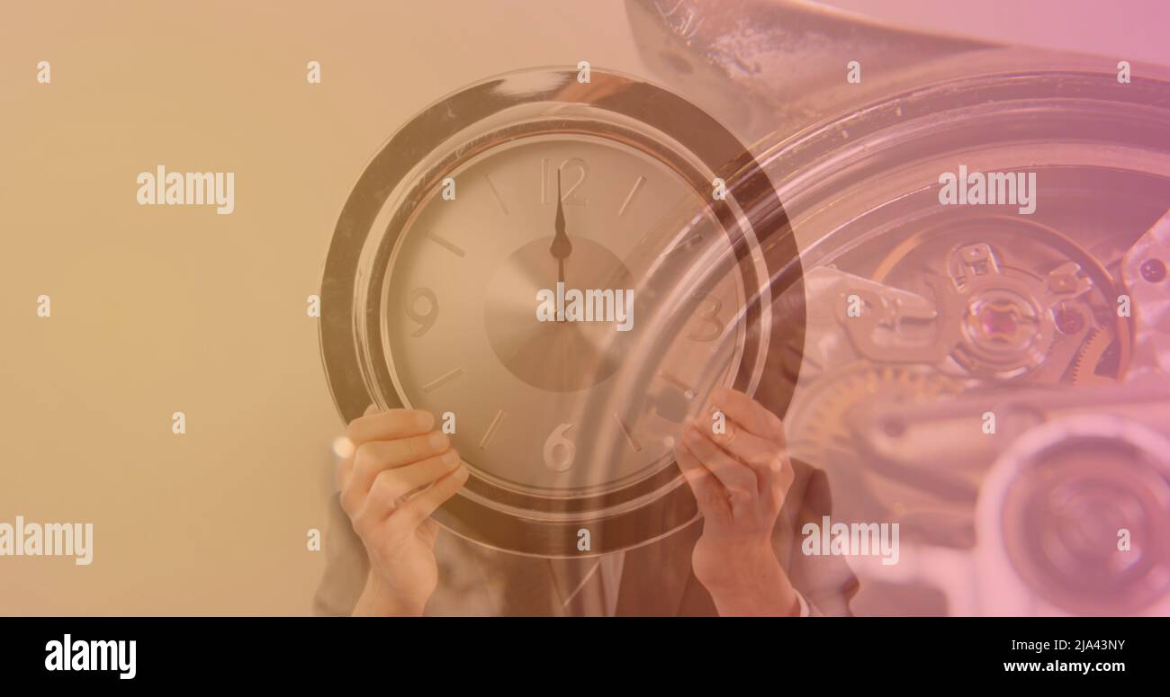 Image of clock over hands holding clock Stock Photo - Alamy