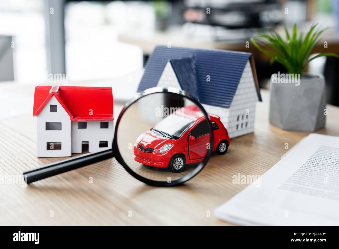 house models near magnifier and toy car on table, tax inspection ...