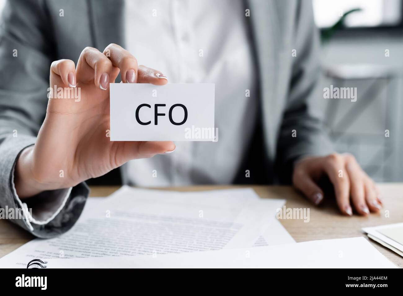cropped view of woman holding paper with cfo lettering in office Stock ...