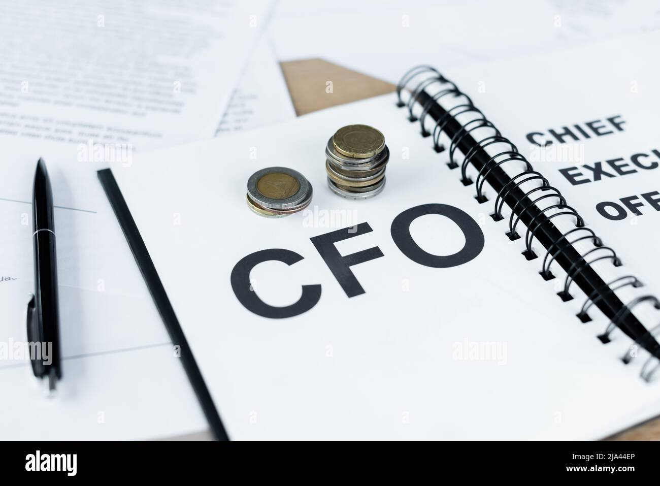 silver and golden coins on notebook with cfo lettering near pen Stock ...