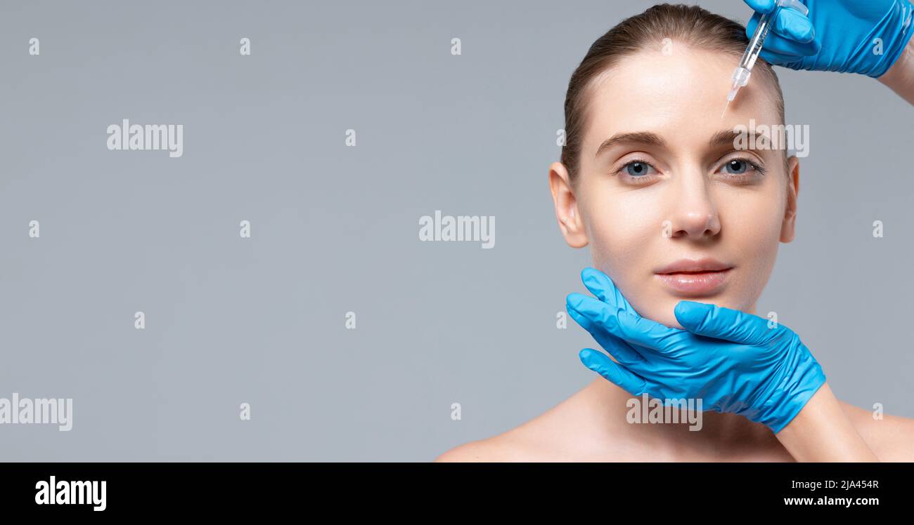 Portrait of young girl doing cosmetology botox injections on forehead ...