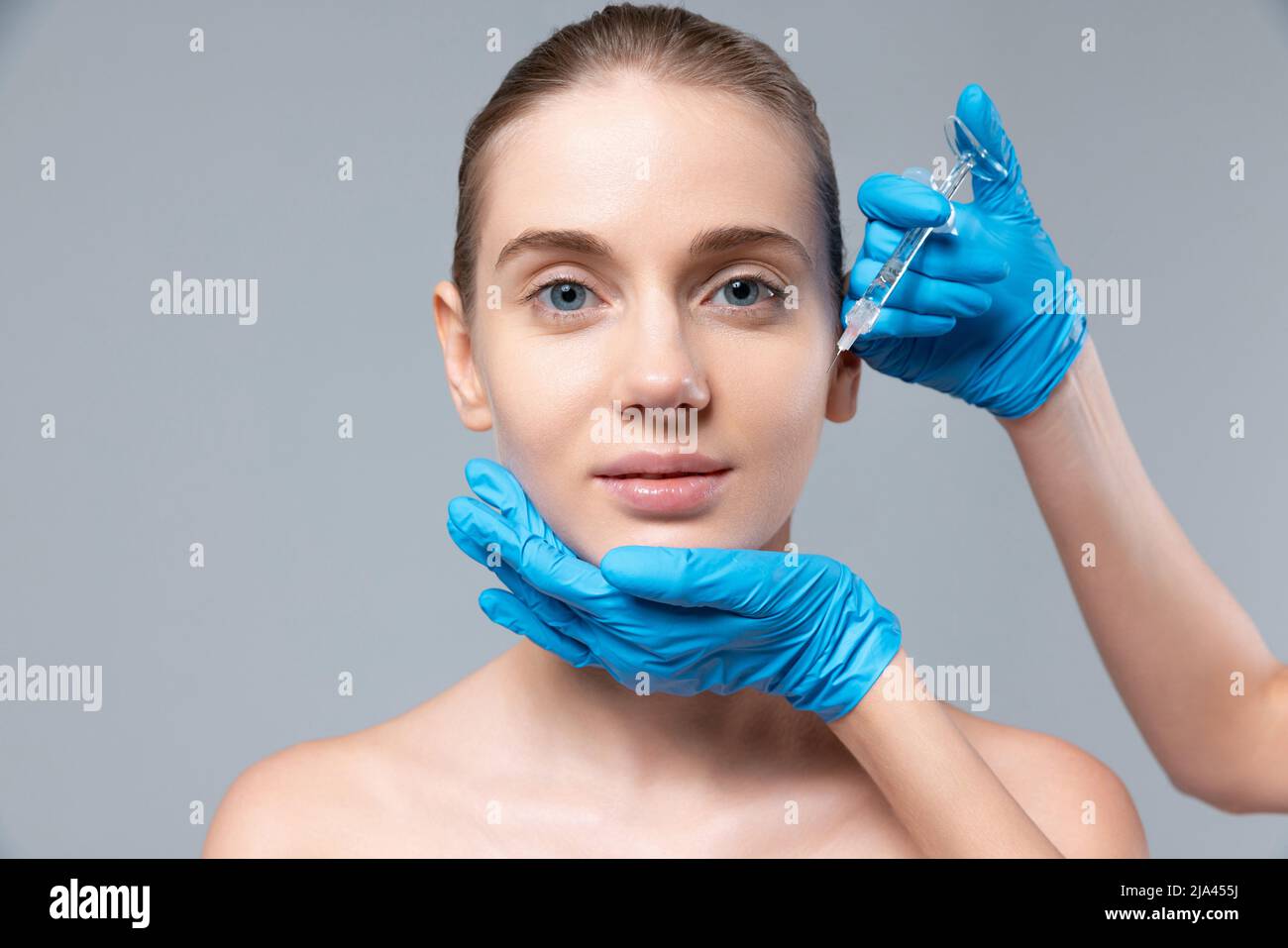 Portrait of young girl doing cosmetology injections on cheeks isolated ...