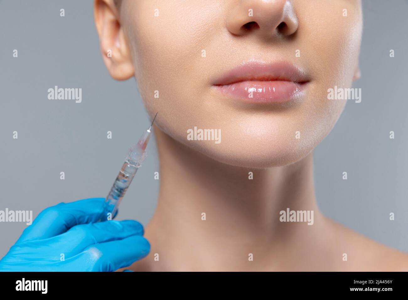 Cropped image of girl doing cosmetology injections on chin, changing ...