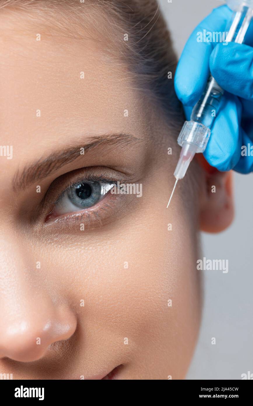 Cropped close-up image of young girl doing cosmetology botox injections ...