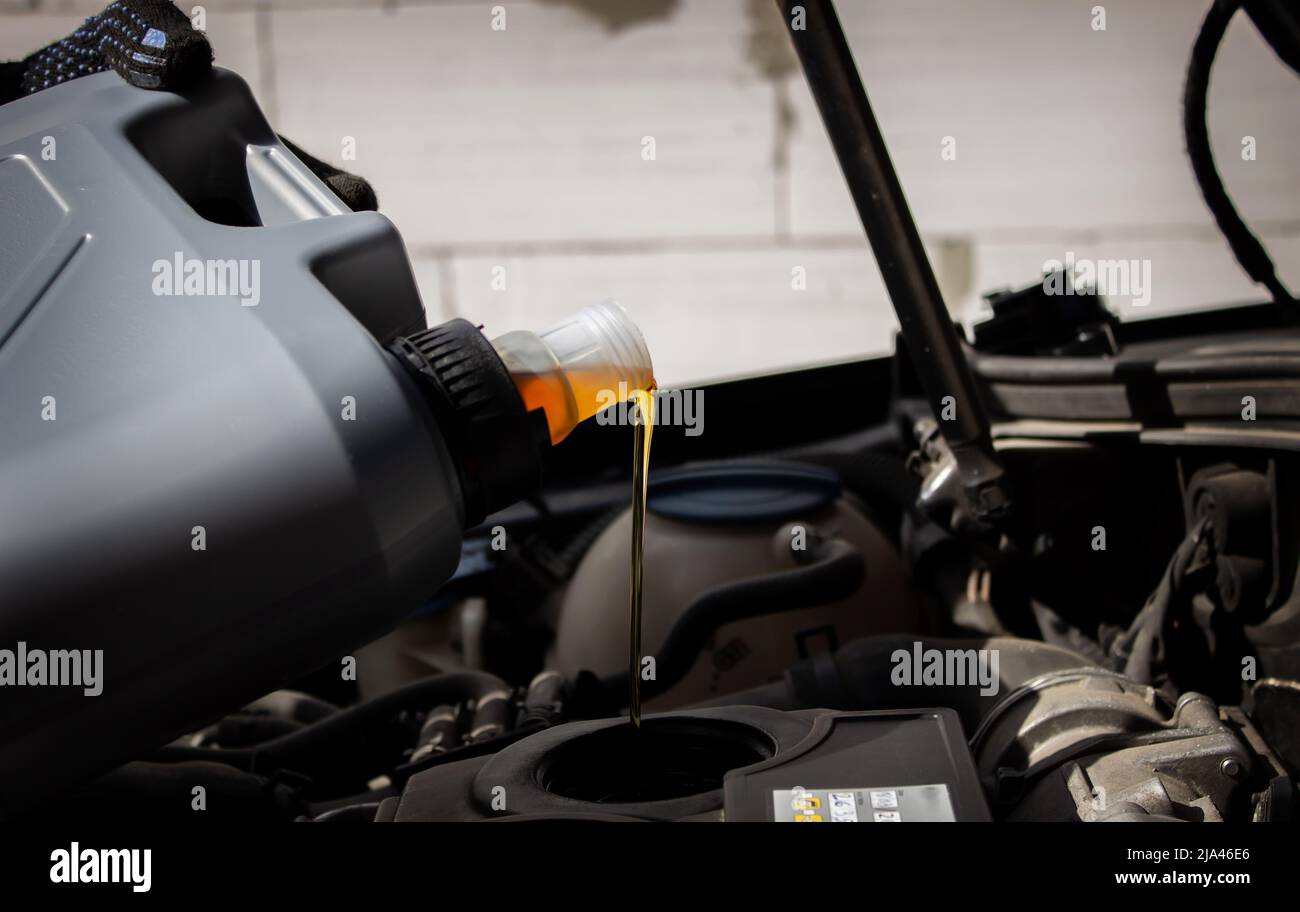 Refueling and pouring oil quality into the engine motor car ...