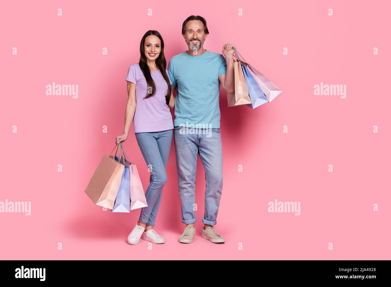 Full size photo of two cheerful nice partners embrace hold packages ...