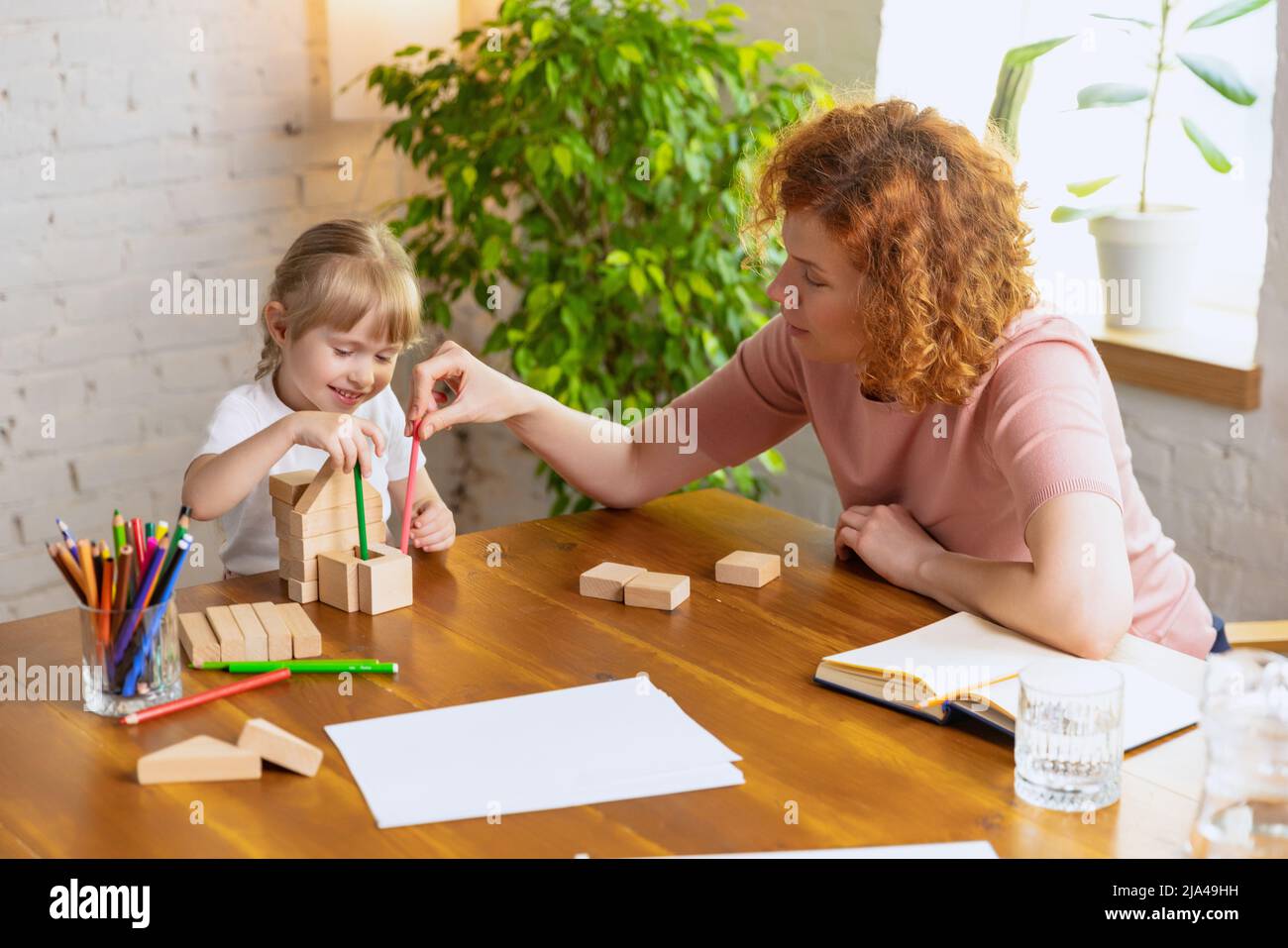 Happy kind woman and cute little girl, mother and daughter playing with ...