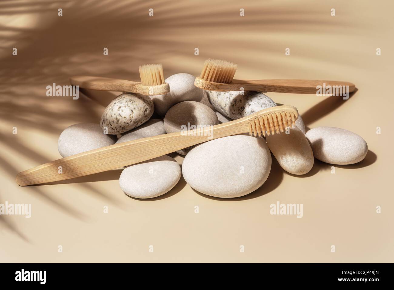 Organic wooden bamboo toothbrush and white sea pebbles on beige ...