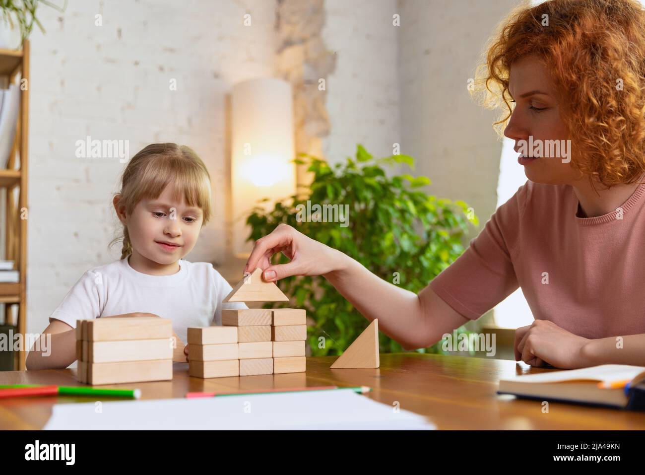 Develop fine motor skills and logical thinking. Smiling woman and cute ...