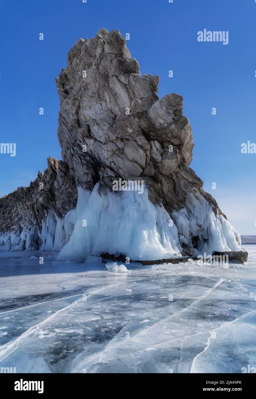 Frozen Baikal lake with transparent cracked blue ice and Ogoy island ...