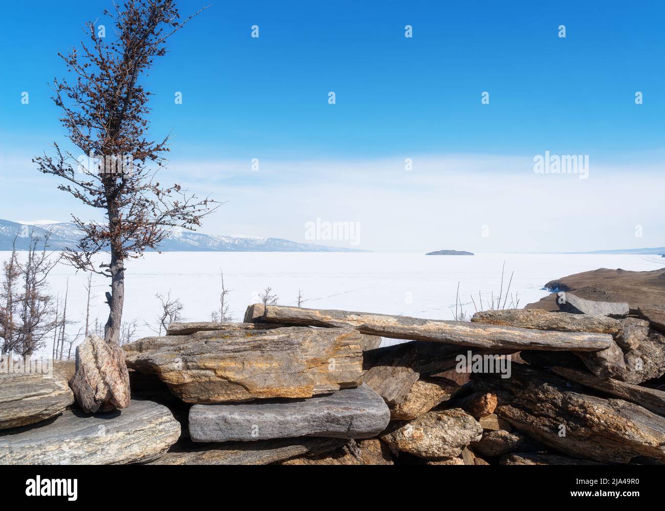 Winter landscape with mountains and dark blue ice of Baikal Lake in ...