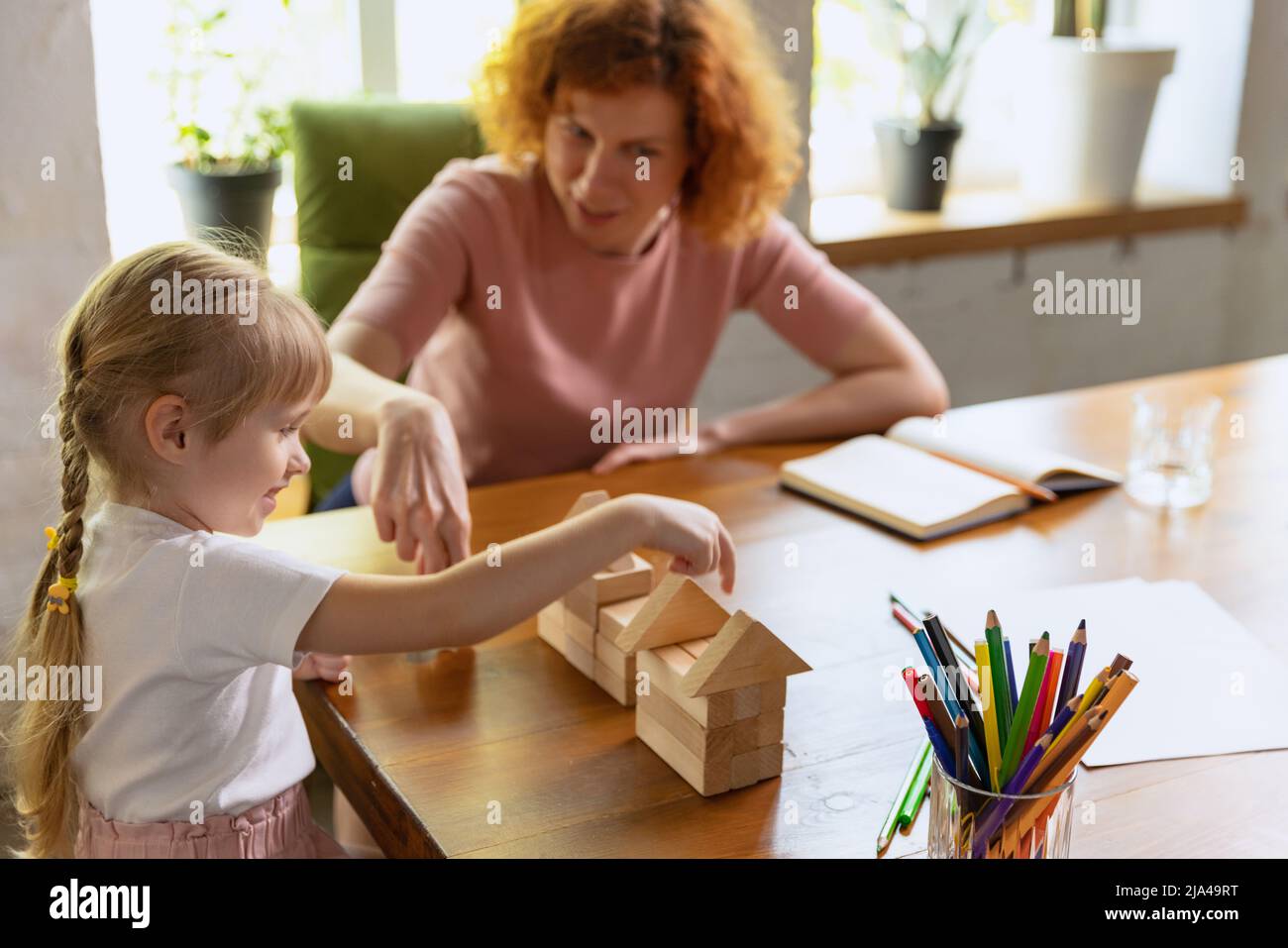 Develop fine motor skills and logical thinking. Smiling woman and cute ...