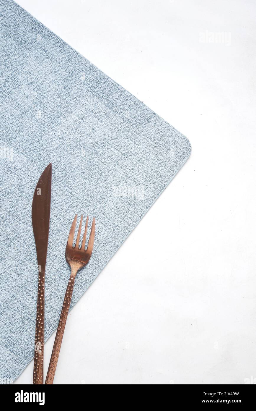 sliver cutlery fork and knife on a table mat on white Stock Photo - Alamy