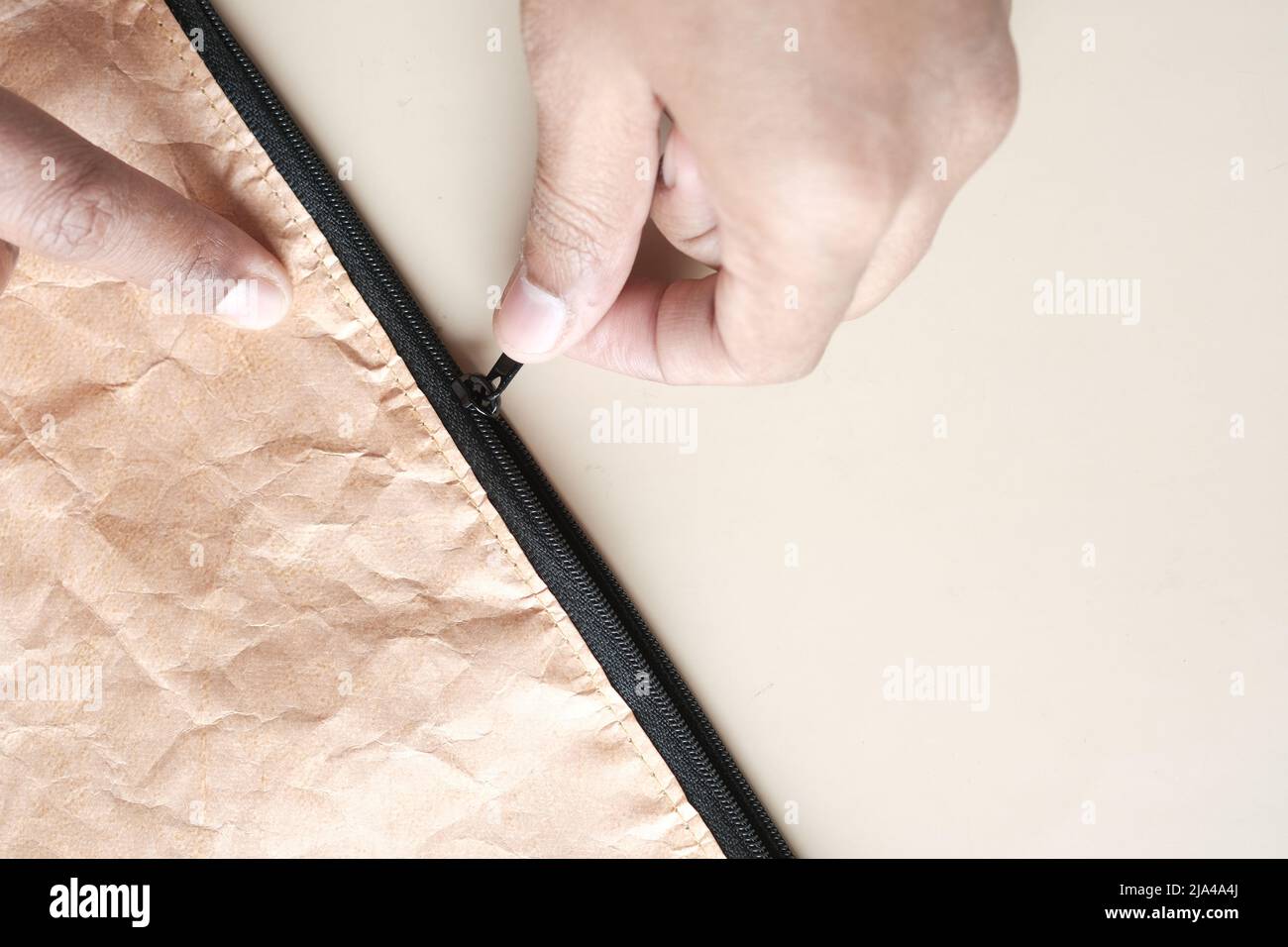 hand in a Zipper on a small paper bag Stock Photo - Alamy