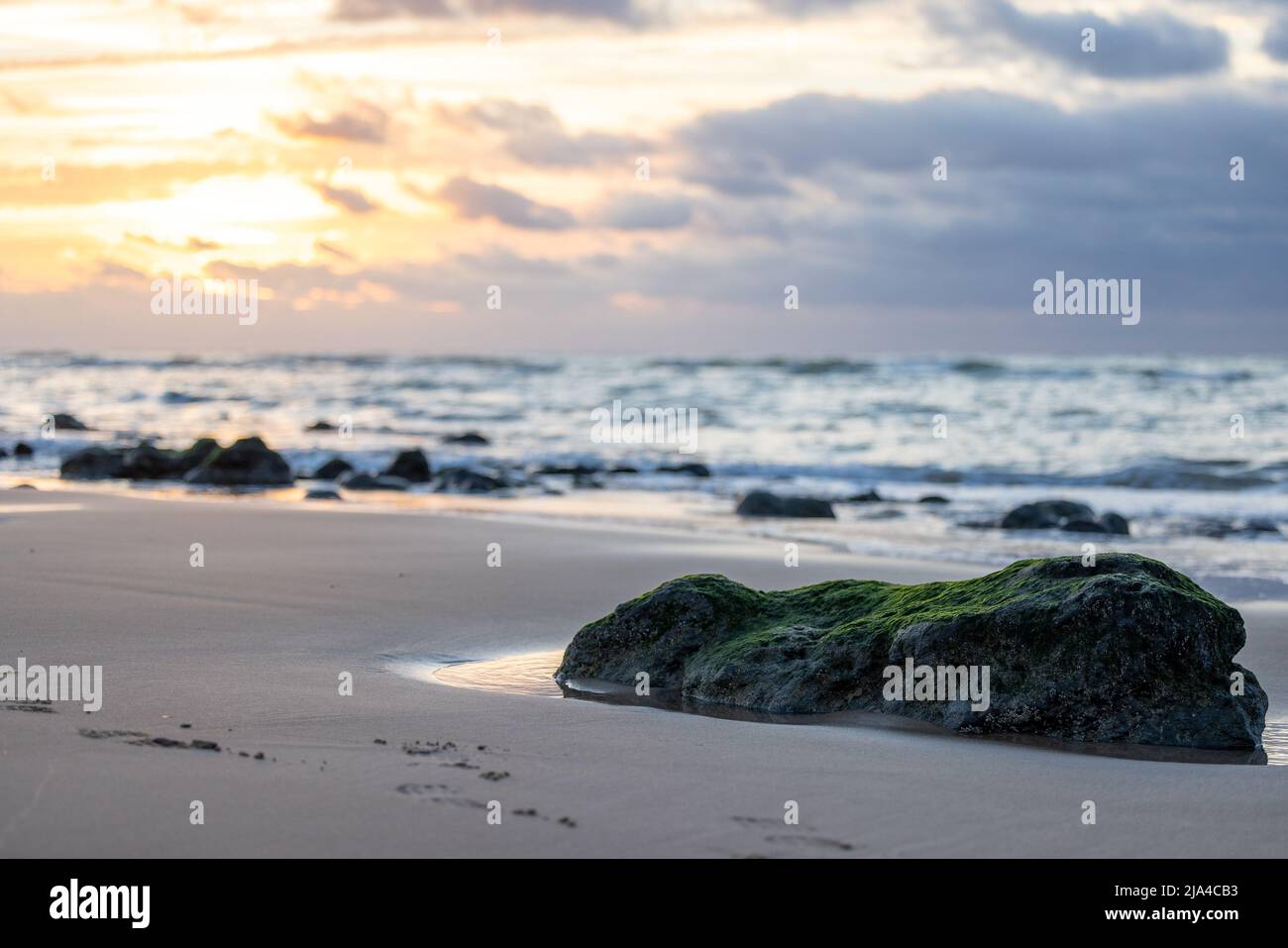 Soft colored dramatic sunset with dark clouds in the background with ...